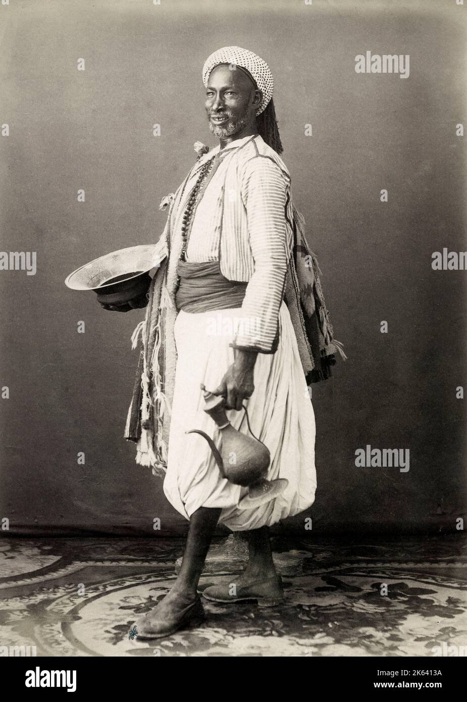 19th century vintage photograph: North African man with jug and dish ...