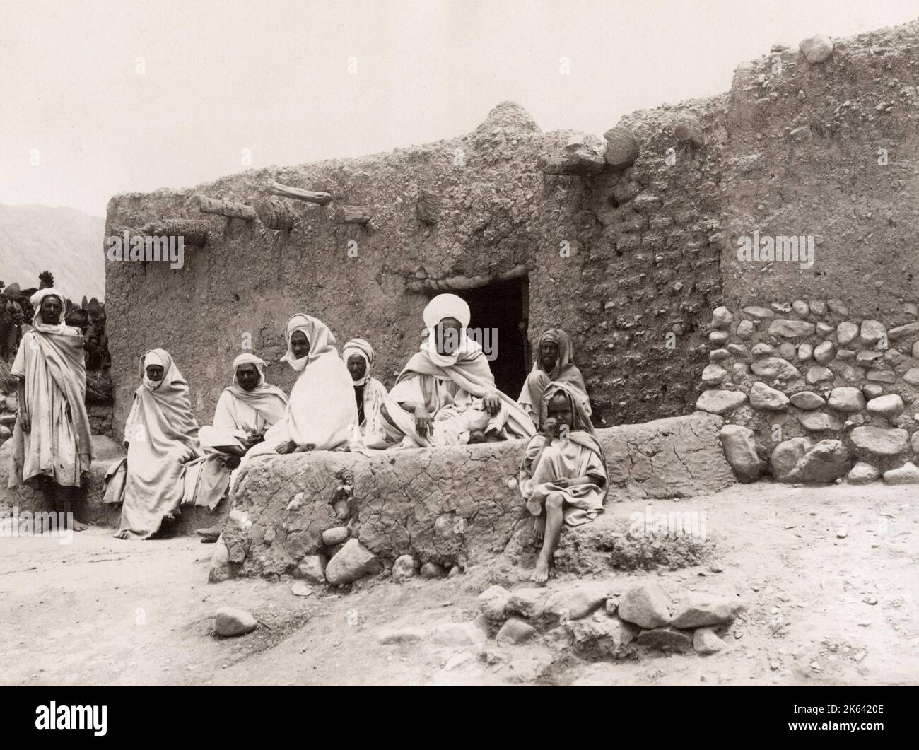 Arab men and children outside a cafe, El Kantara, Biskra region ...