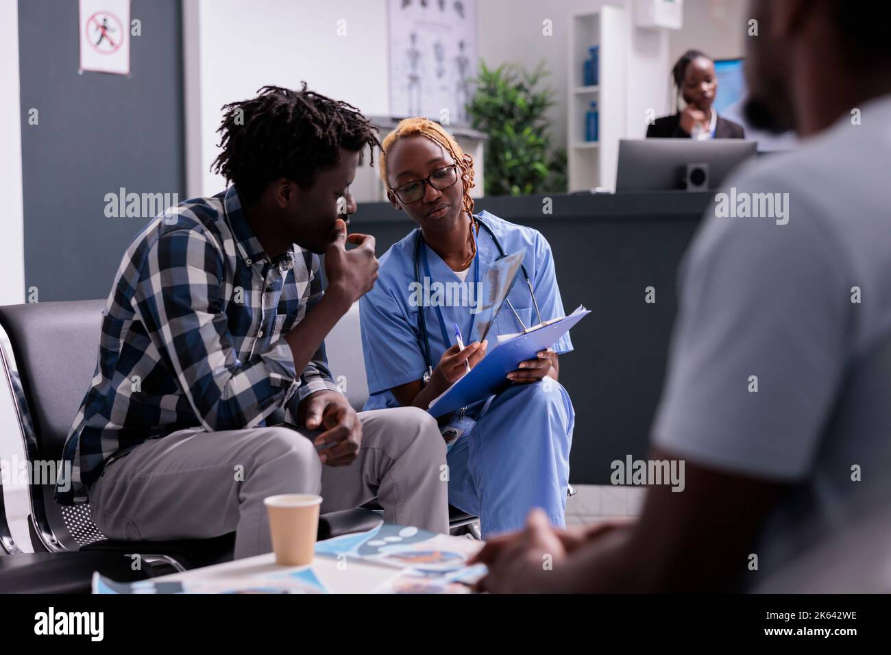 Nurse showing x ray scan to patient in waiting area lobby, explaining ...