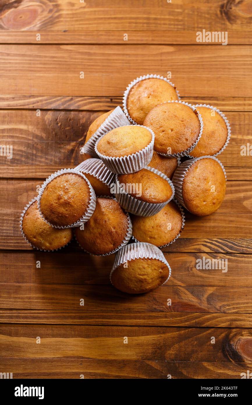 Homemade muffins in paper wrap on wooden board Stock Photo - Alamy