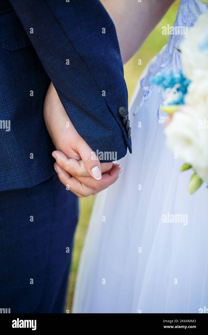 Bride and groom hold hands on wedding day Stock Photo - Alamy