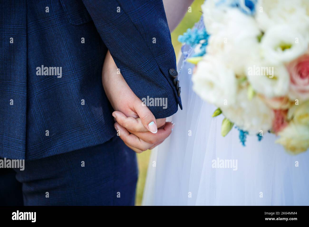 Bride and groom hold hands on wedding day Stock Photo - Alamy