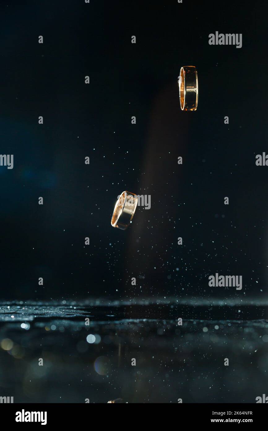 Gold wedding rings with water splashes Stock Photo - Alamy