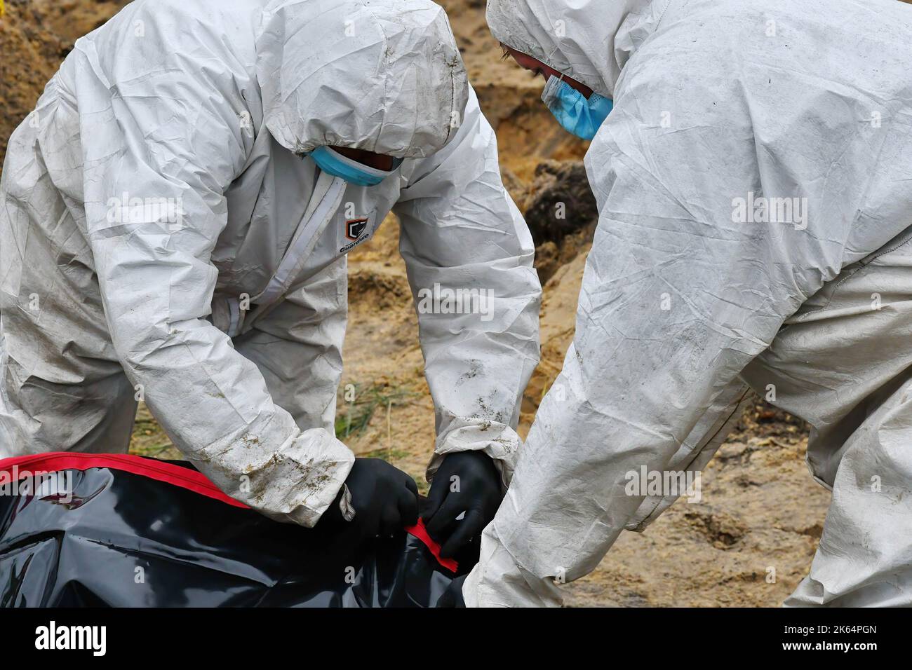 Members of a forensic team at work during an exhumation at a mass grave ...