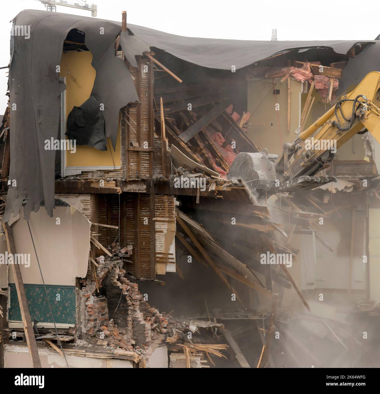 Demolishing a building with a large backhoe. Overcast day. Backhoe ...