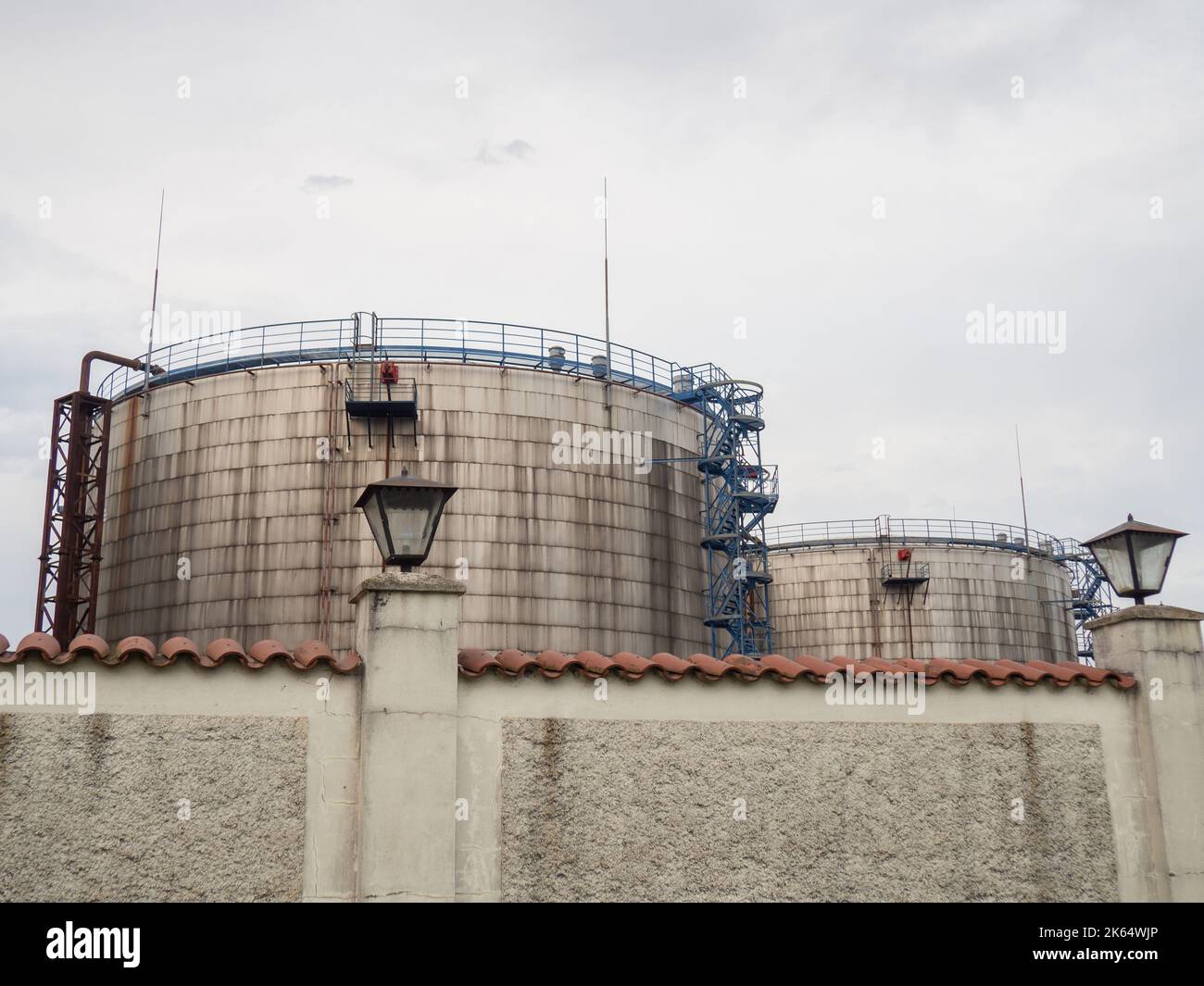 Large fuel tanks. Tanks and ladders of the tank farm. The gloomy ...