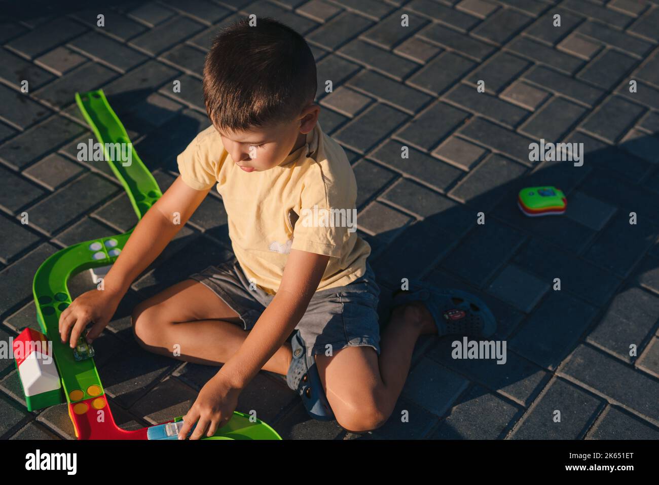 Boy playing in the yard of the house with multicoloured and attractive ...