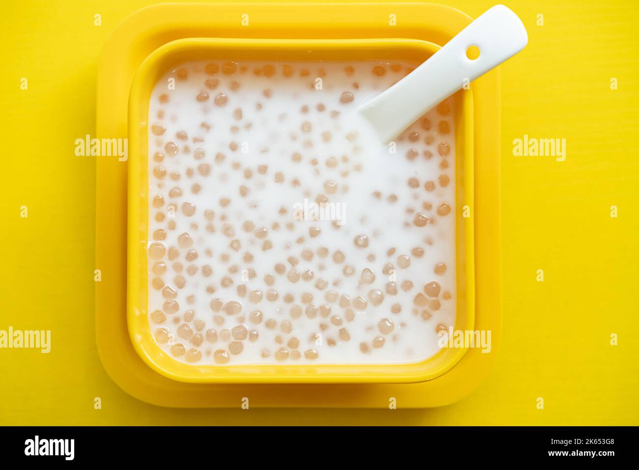 top view bowl of Chinese syrup of sago with coconut juice on yellow ...