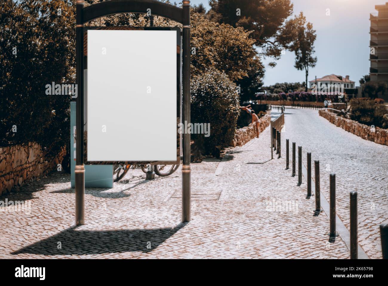 Mockup of an empty vertical ad poster in urban settings on the pavement ...