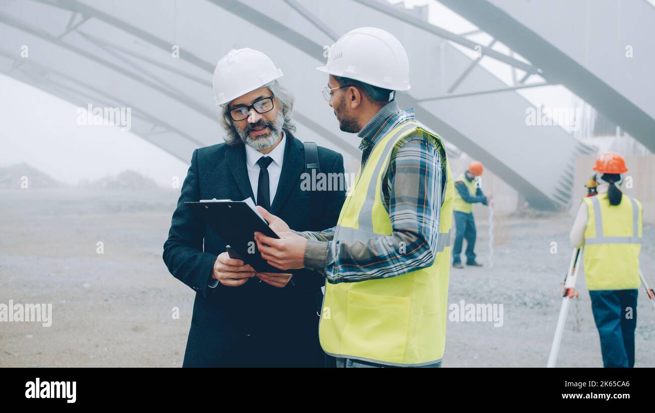 Project manager is talking to builder discussing construction work in ...
