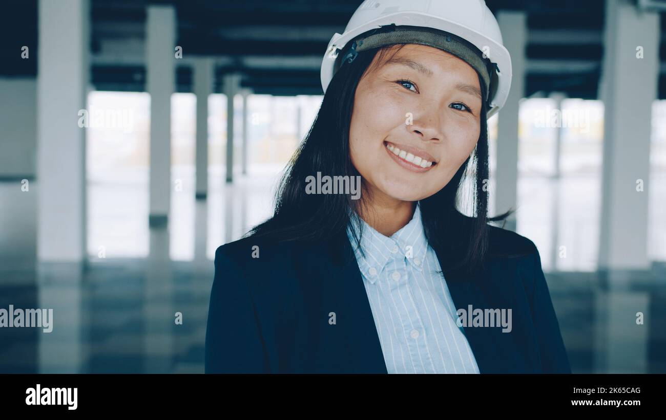 Portrait of Asian woman engineer standing indoors new building wearing ...