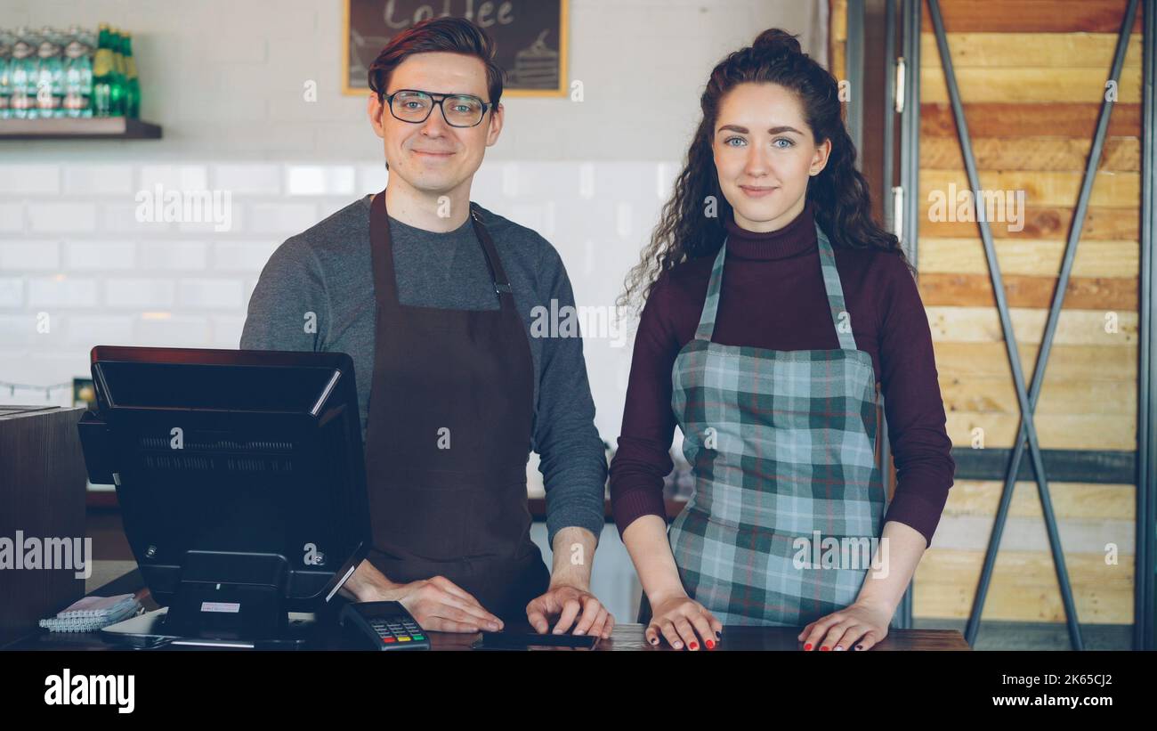 Portrait of two partners small business owners standing at cashier's ...