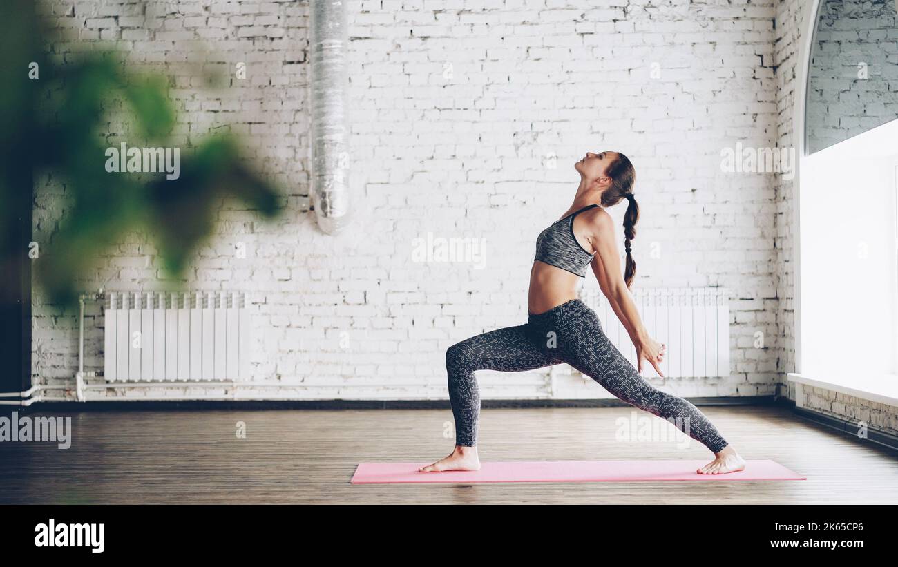 Attractice young woman advanced yoga student is doing combination of ...