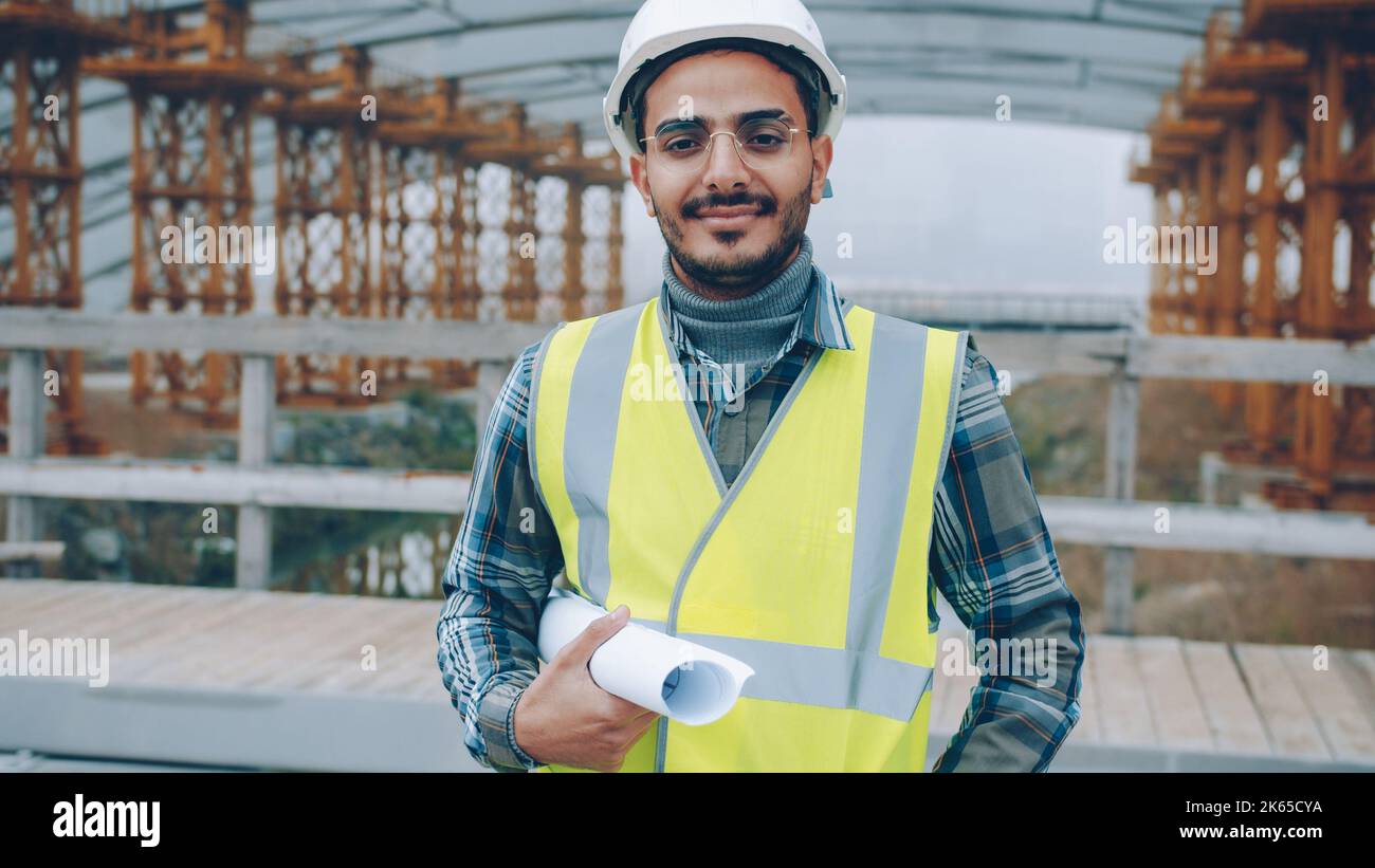 Portrait of good-looking Middle Eastern guy wearing safety helmet and ...