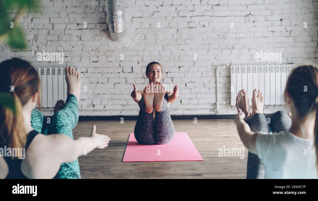 Pretty female yoga instructor is demonstrating different variations of ...