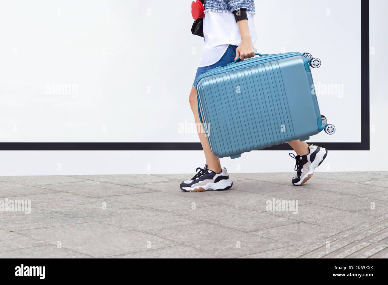 Female traveler walking with blue suitcase on white background Stock ...