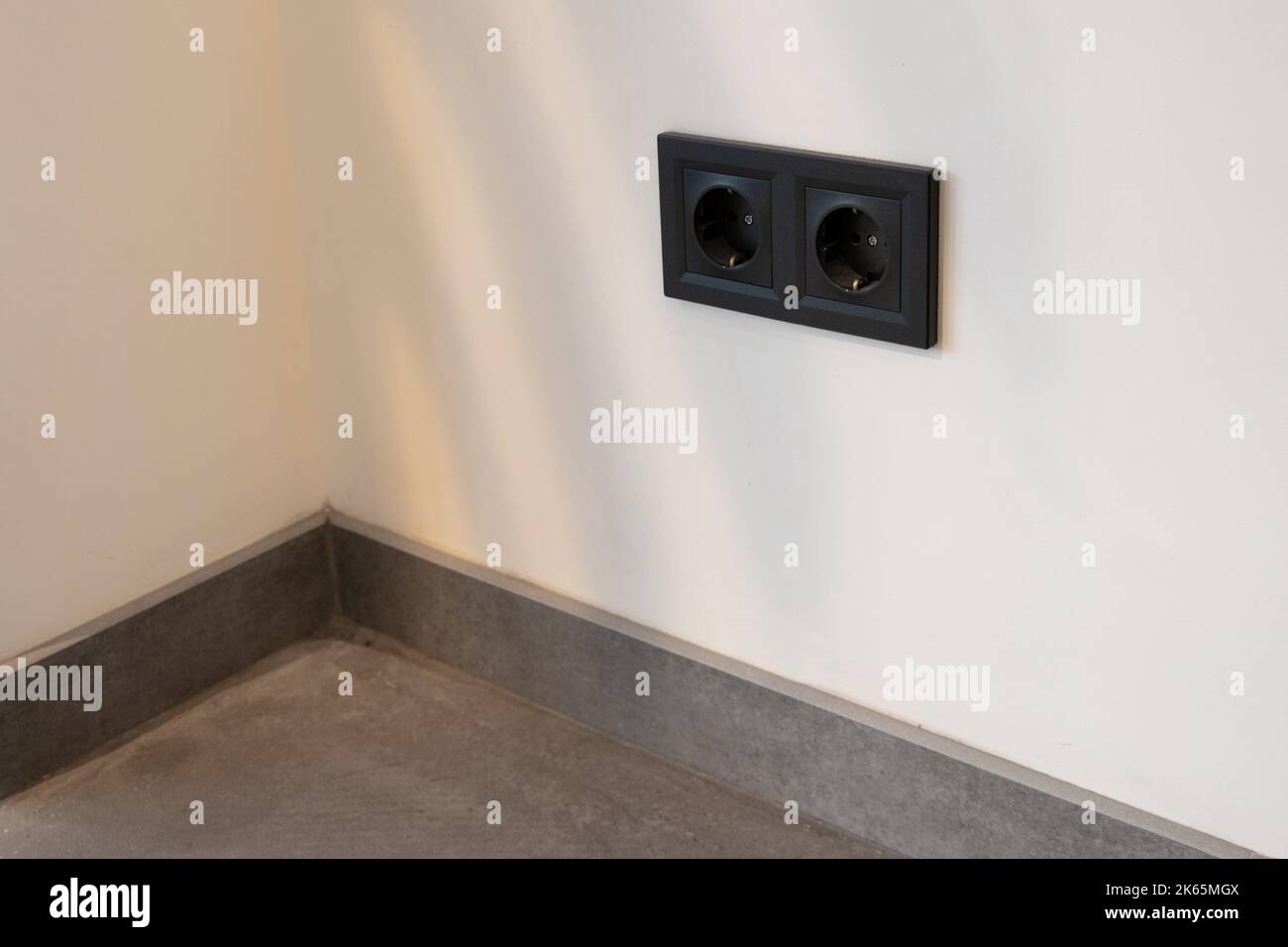 black plastic socket on the white wall of the house, socket on the wall ...