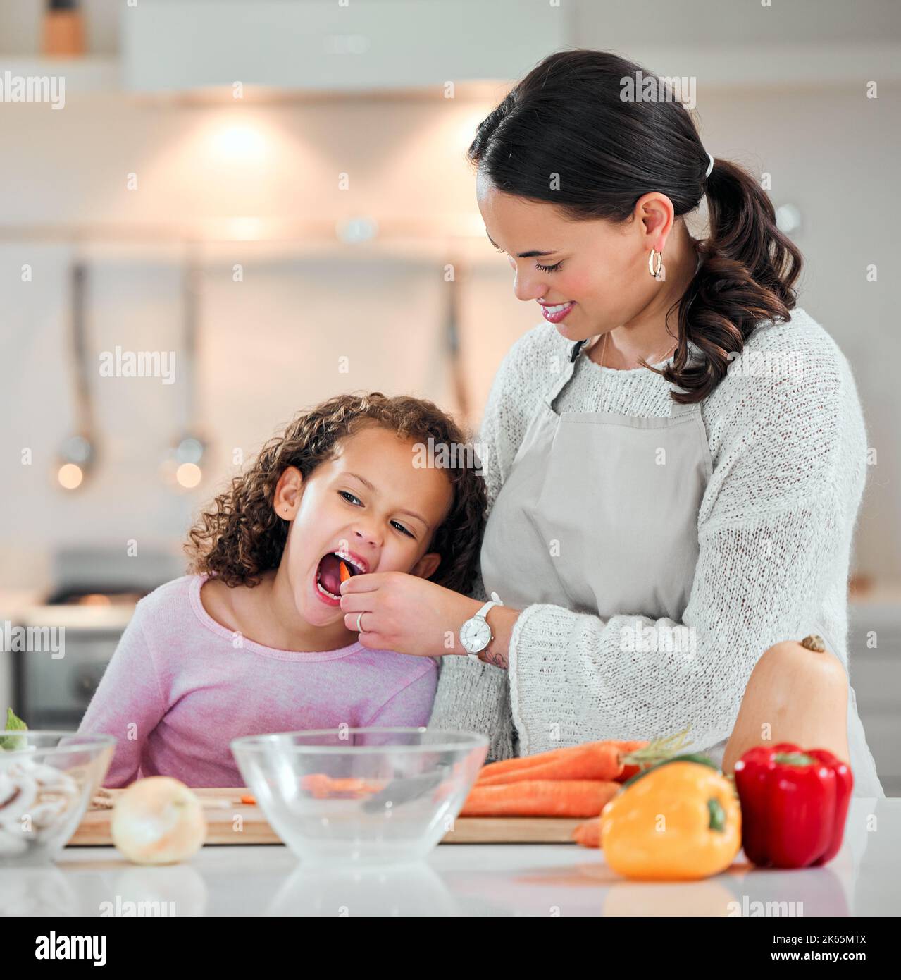 Want a taste. a little girl and her mother cooking at home Stock Photo ...