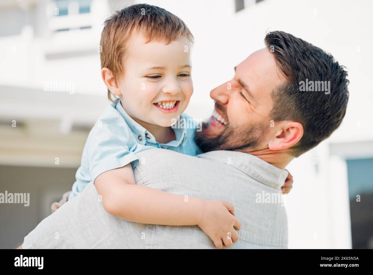 Happy caucasian father holding and comforting cheerful son while having ...