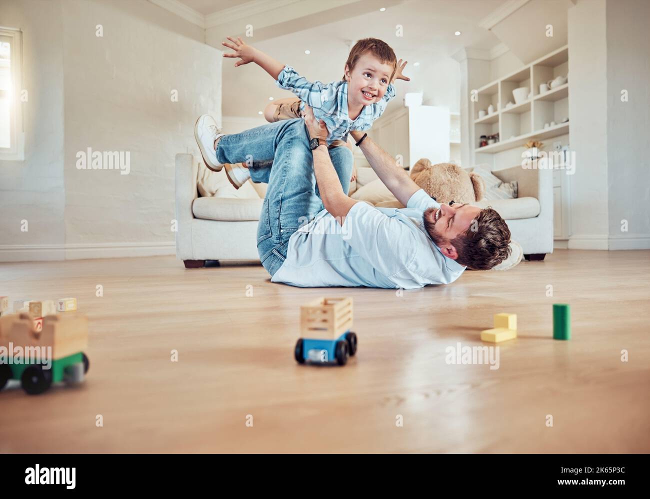 Father lifting his son. Dad lying on the floor lifting his child ...