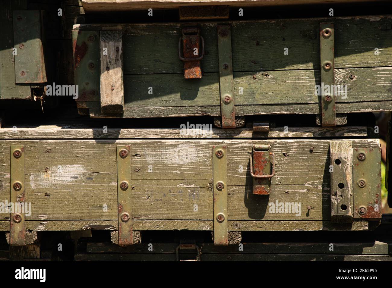 Old green wooden weapon boxes stand outside in the sun,arms depot Stock ...
