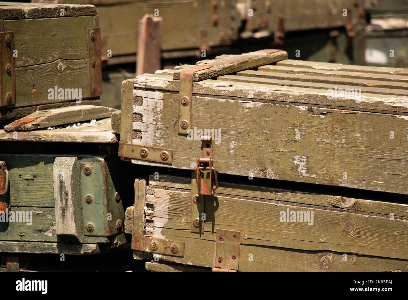 Old green wooden weapon boxes stand outside in the sun,arms depot Stock ...