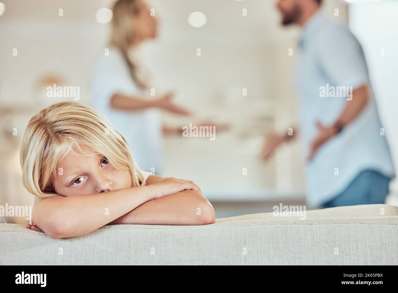 Portrait of sad little girl, parents fighting in the background ...