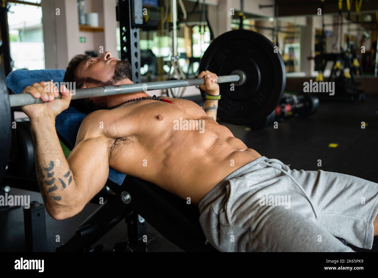 Strong man doing bench press exercises in a gym Stock Photo - Alamy