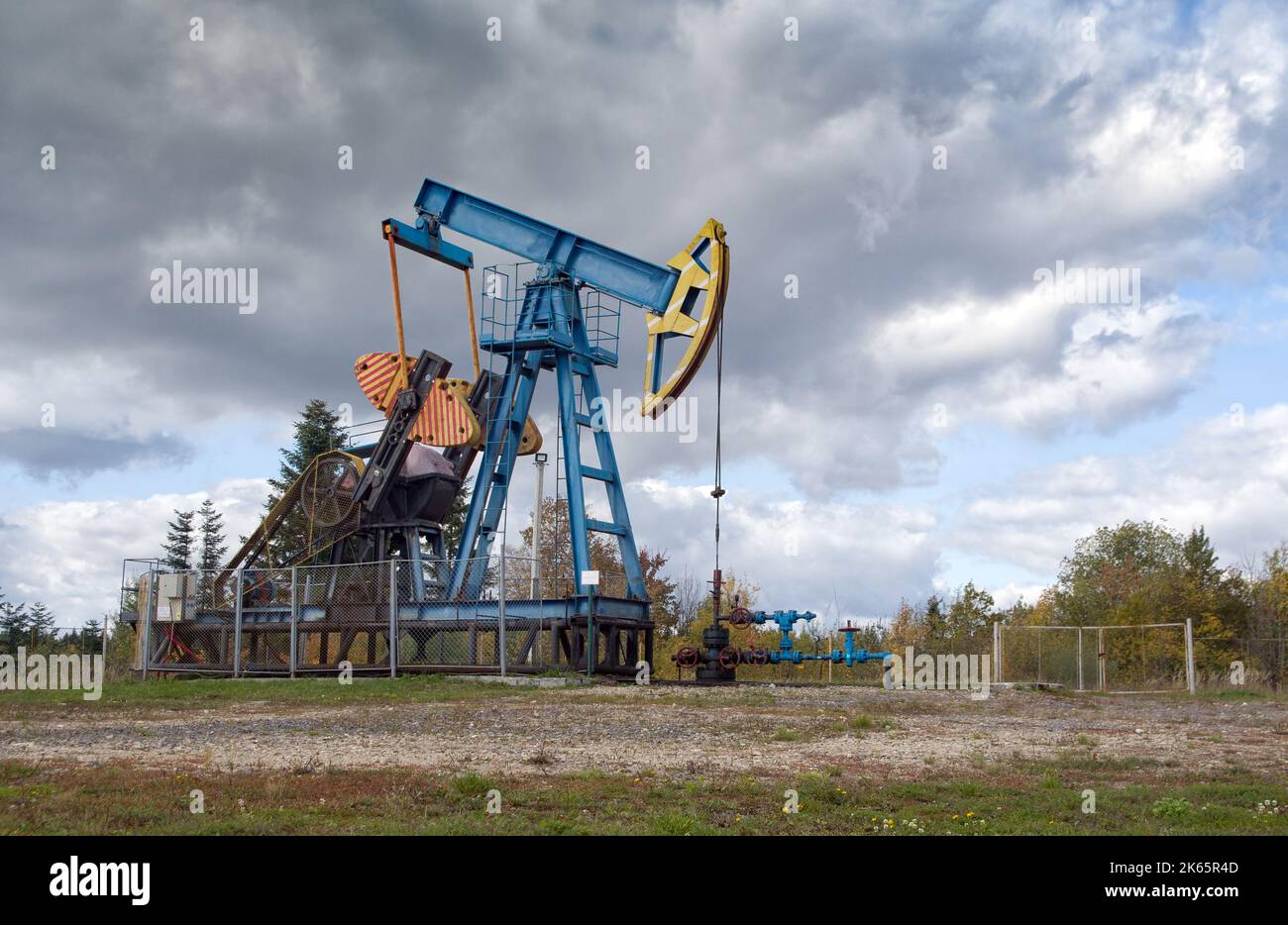Oil rig pump rocking chair against the background of the autumn forest ...