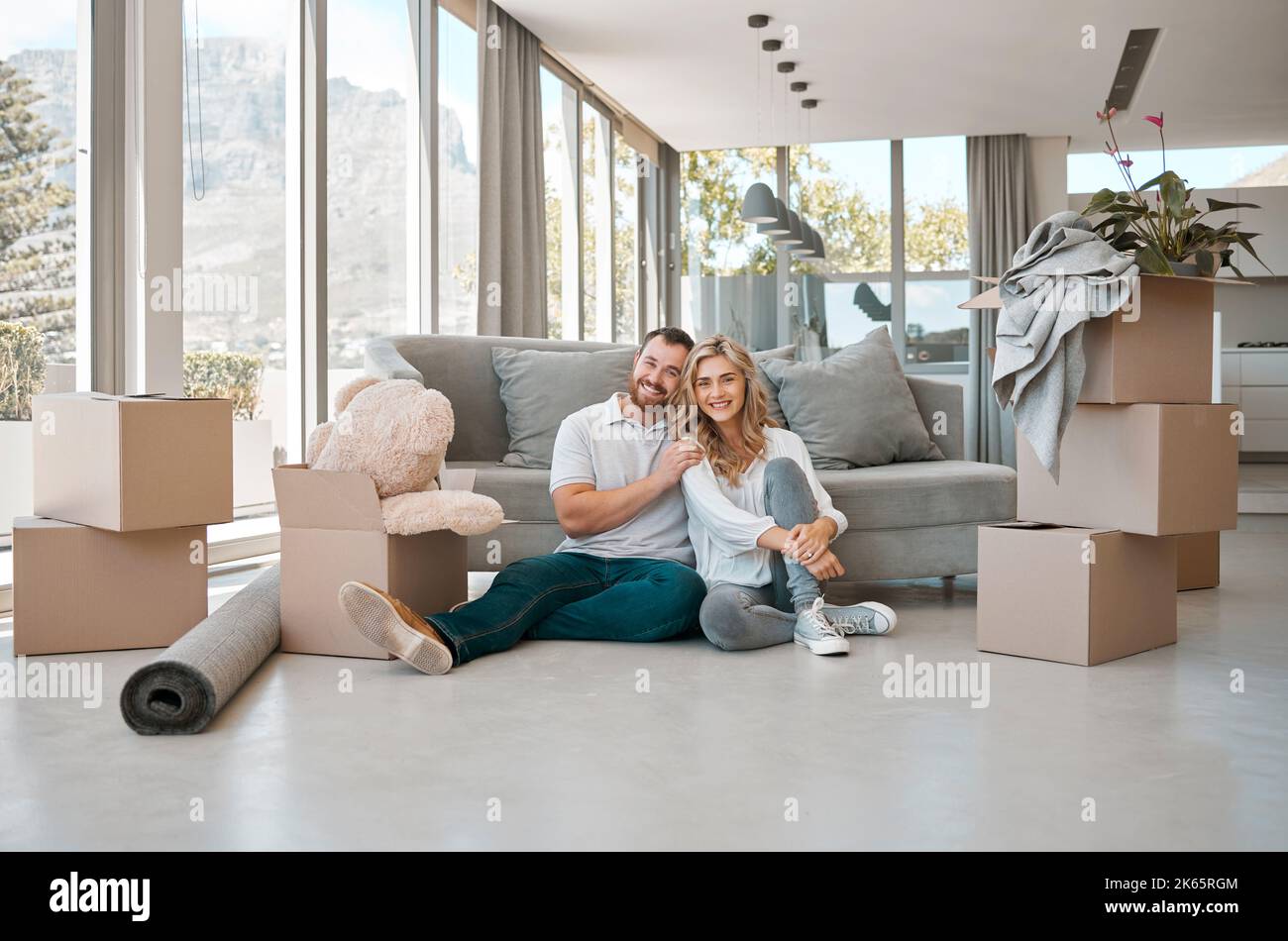 Young happy caucasian couple hugging sitting on the floor of their new ...