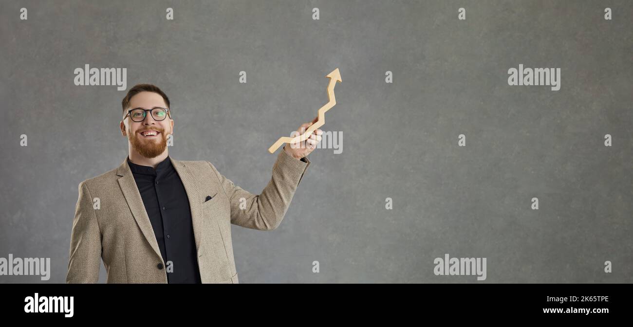 Happy joyful businessman holds a growth arrow as a symbol of success ...