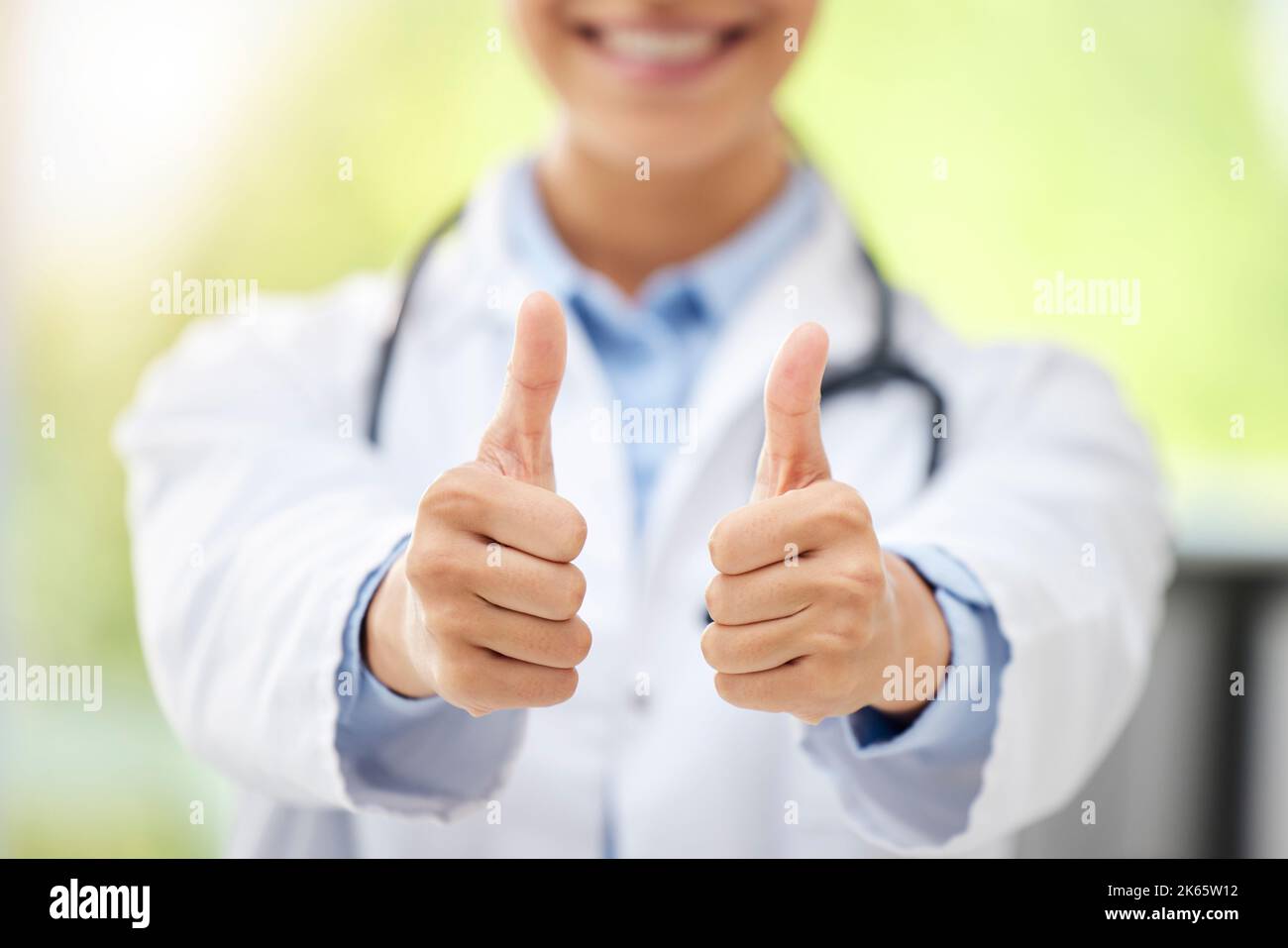 Unknown mixed race doctor making a thumbs up gesture while sitting in ...