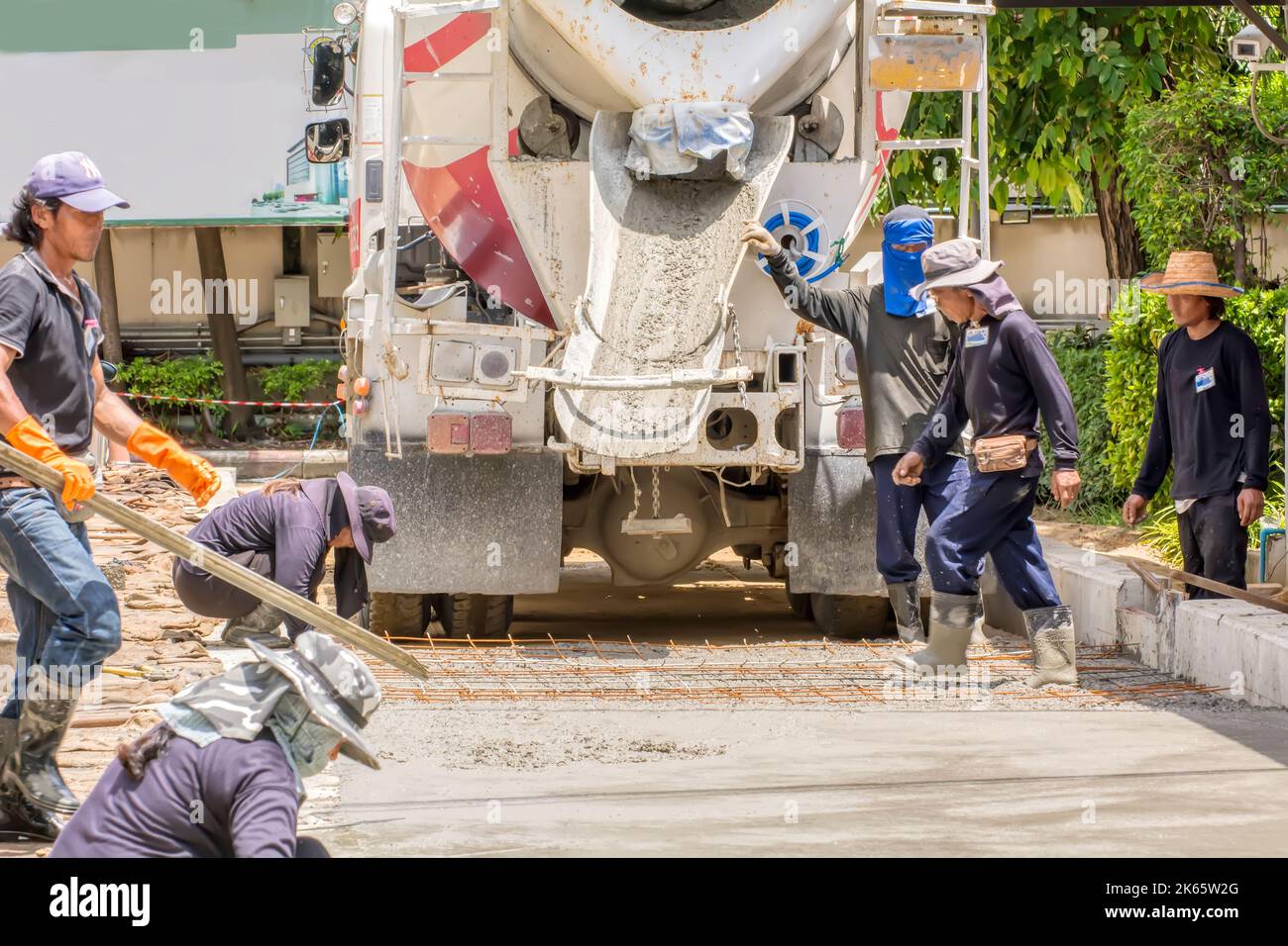 Construction worker pouring cement for doing the road Stock Photo - Alamy