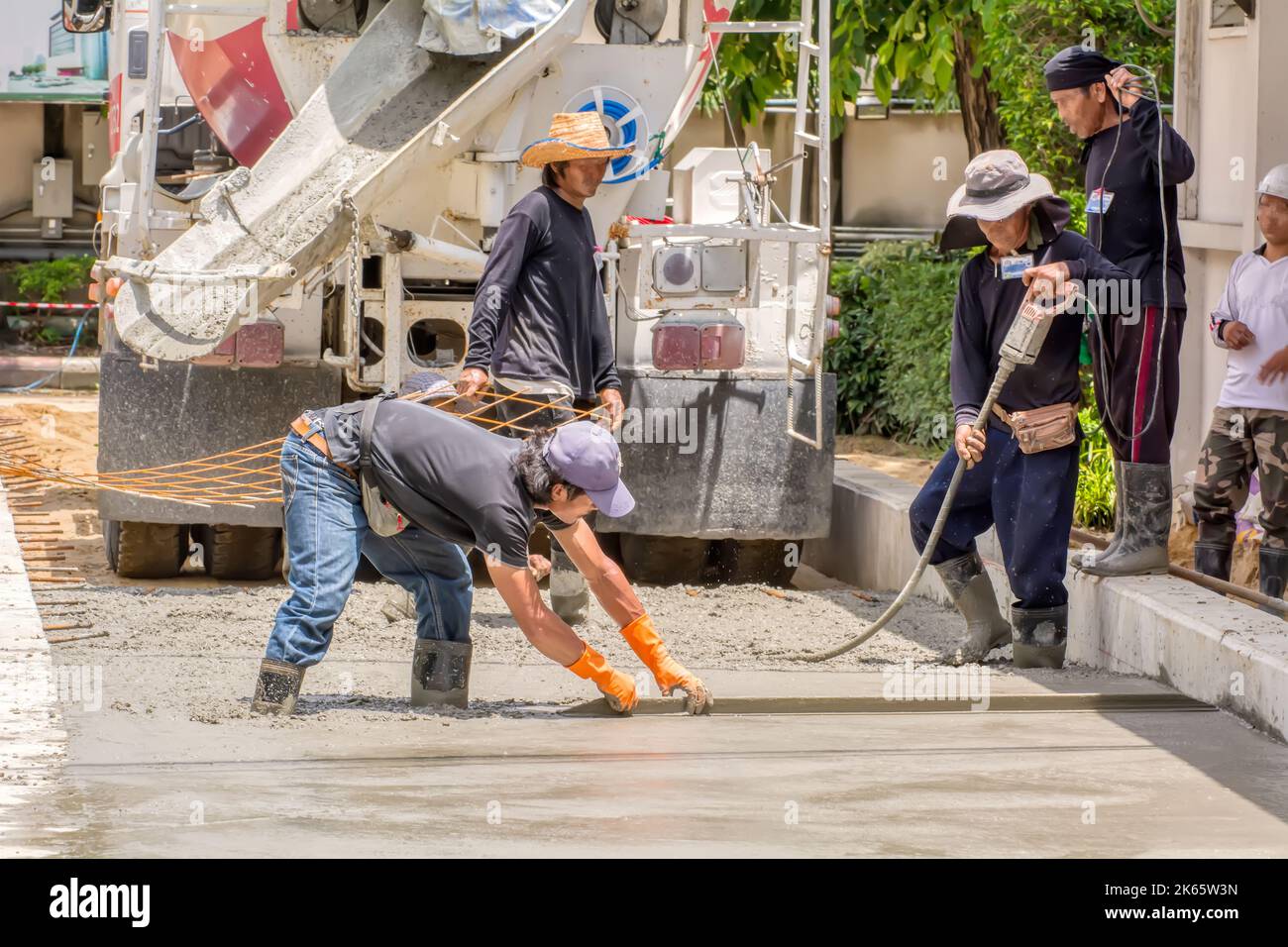 Construction worker pouring cement for doing the road Stock Photo - Alamy