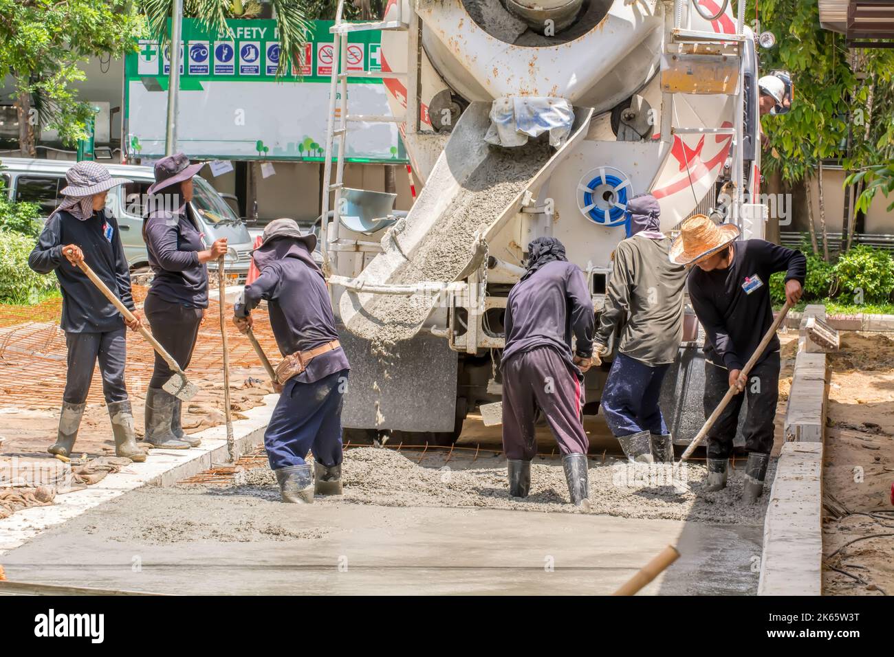 Construction worker pouring cement for doing the road Stock Photo - Alamy