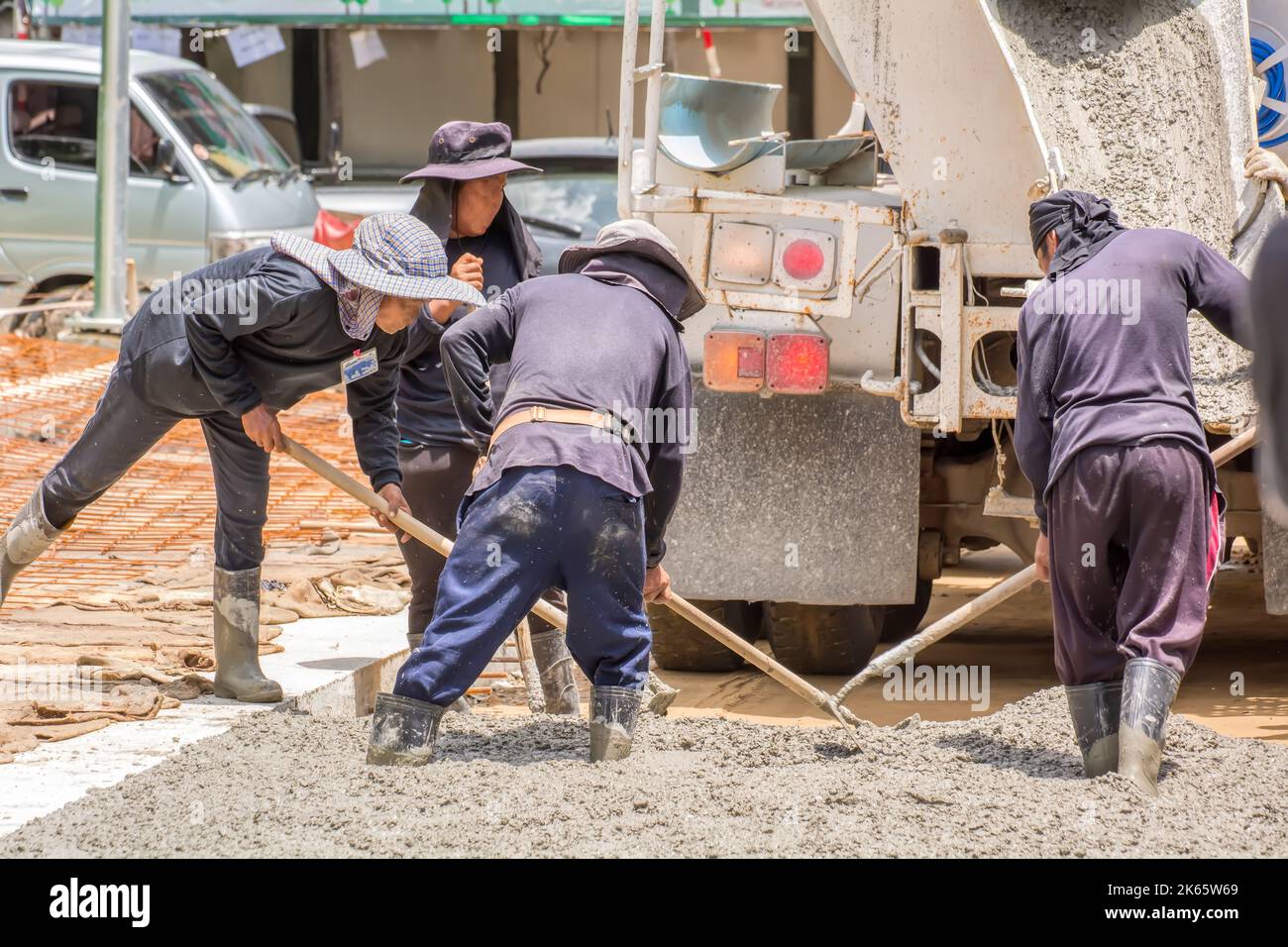 Construction worker pouring cement for doing the road Stock Photo - Alamy