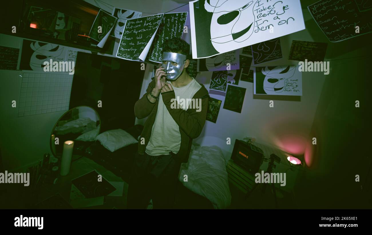 Unknown masked man with mental disorder sitting alone at night feeling ...