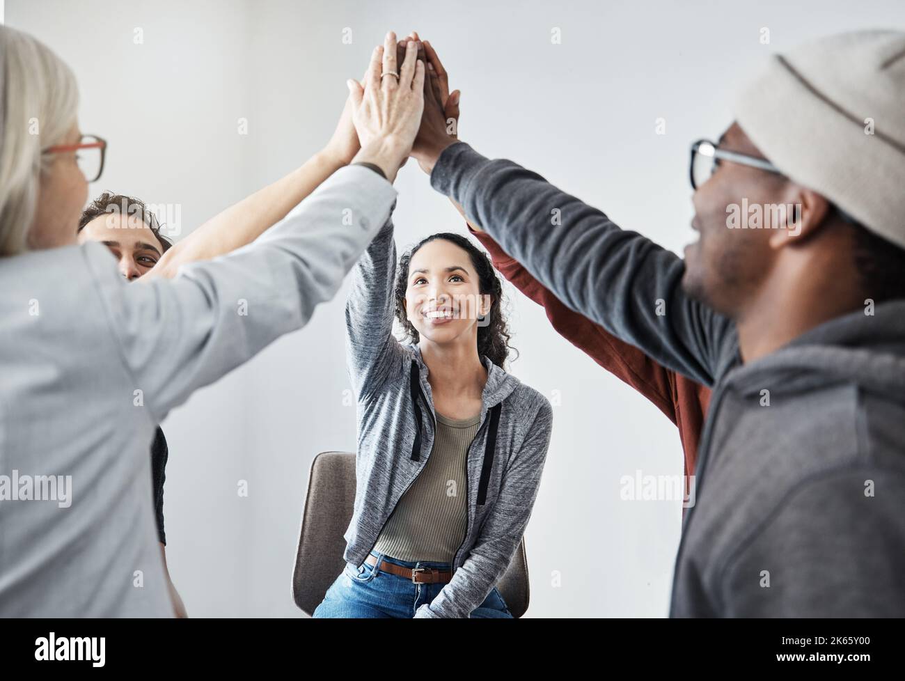 Happy diverse group of businesspeople smiling giving each other a high ...