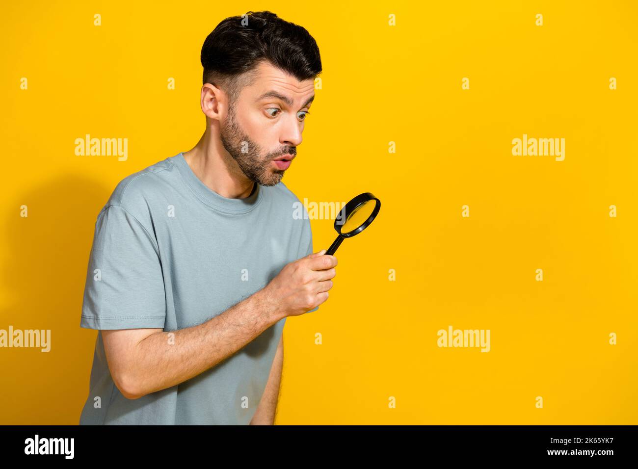 Photo of astonished impressed man wear stylish clothes hold enlarge ...