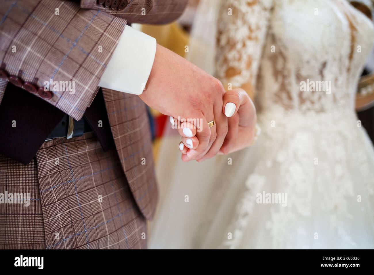 Bride and groom hold hands on wedding day Stock Photo - Alamy