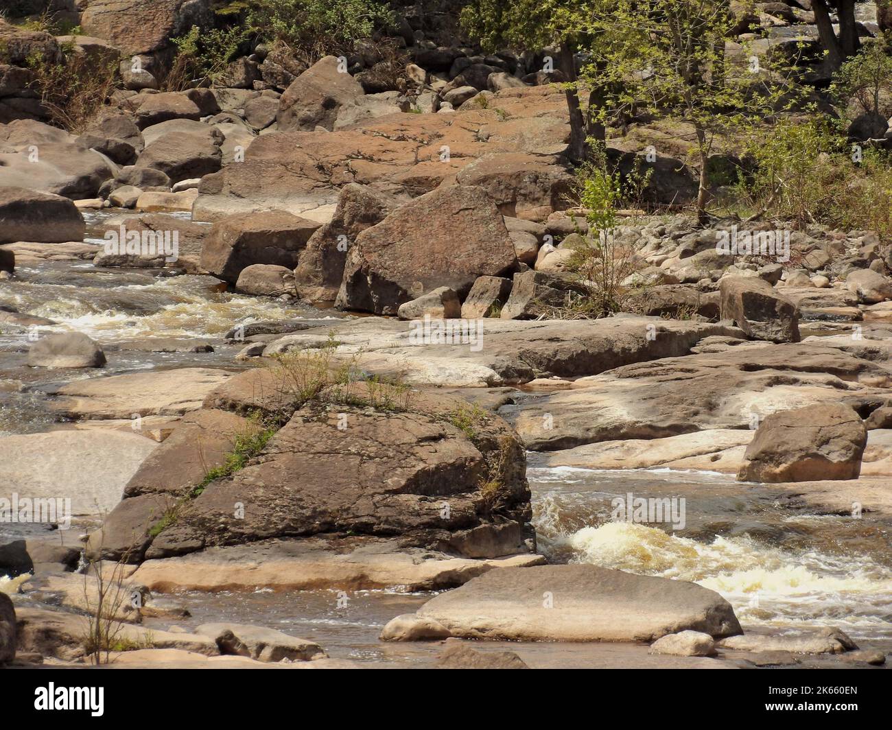 A flowing river water with big rocks Stock Photo - Alamy