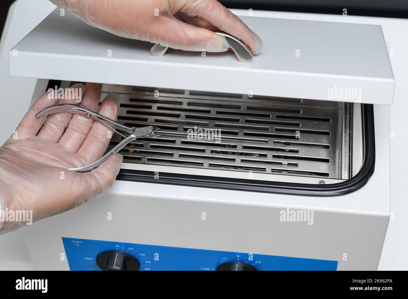 Hand with manicure and pedicure forceps after sterilization and ...