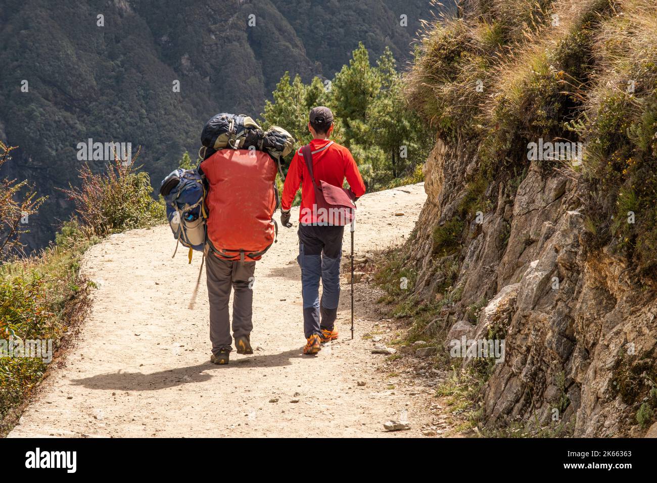 Sherpa carrying the heavy bags of a tourist in Nepal on the Everest Way ...