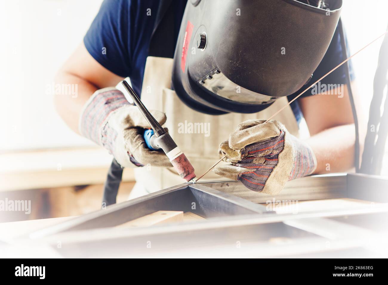 Male in face mask welds with argon-arc welding Stock Photo - Alamy