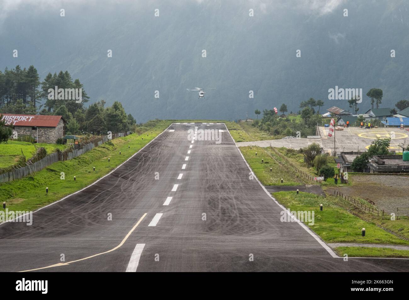 Helicopter coming into land at Lukla airport, looking down the runway ...