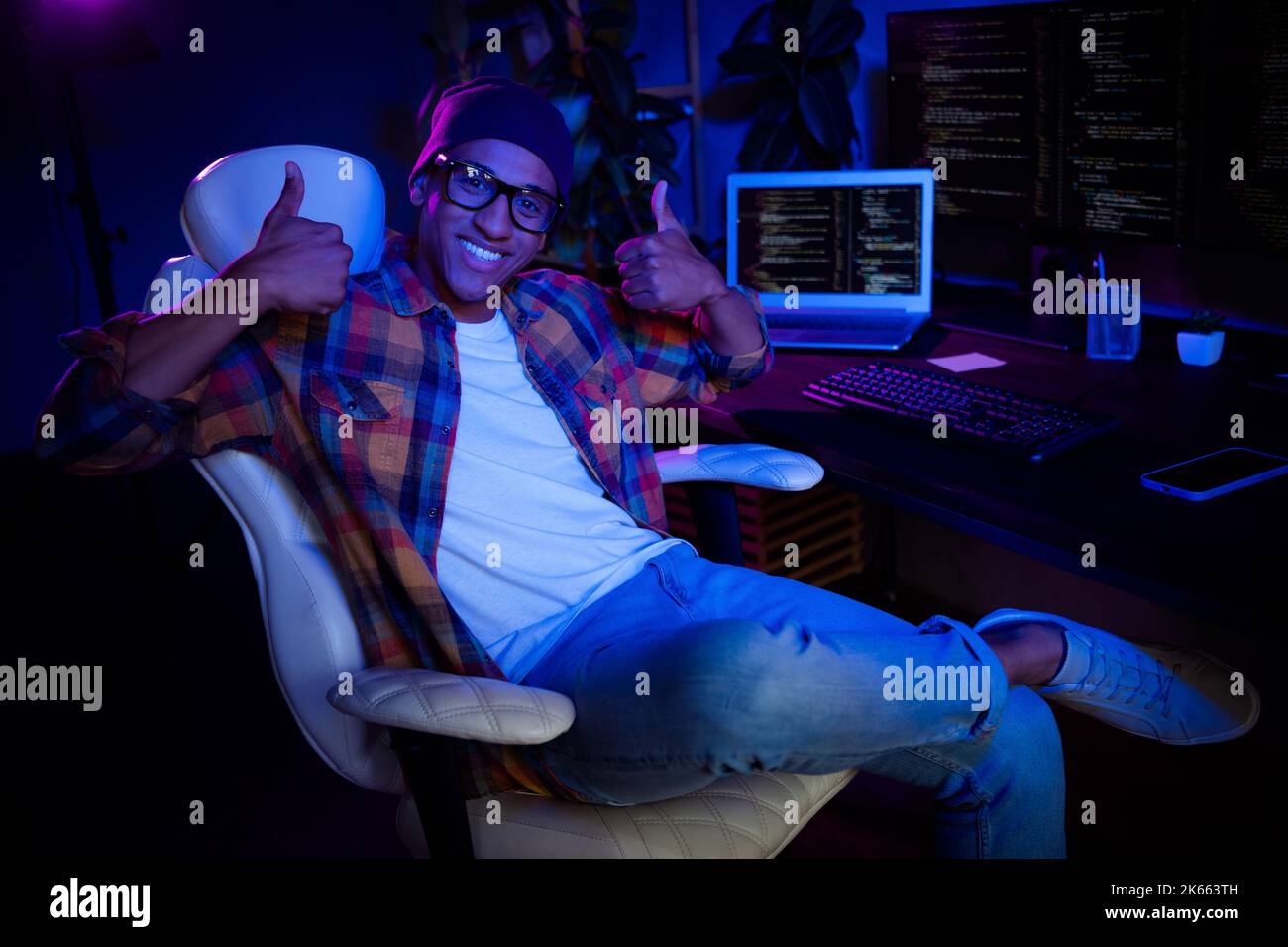 Photo of positive hacker guy sit chair two arms show thumb up feedback ...