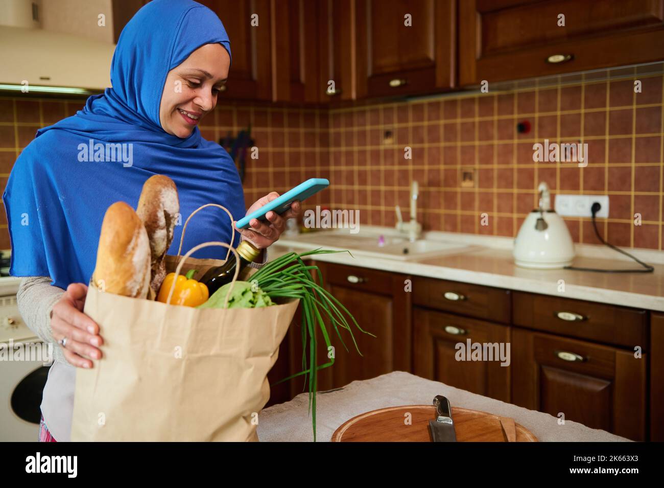 Arab Muslim woman, housewife with head covered in hijab using mobile ...