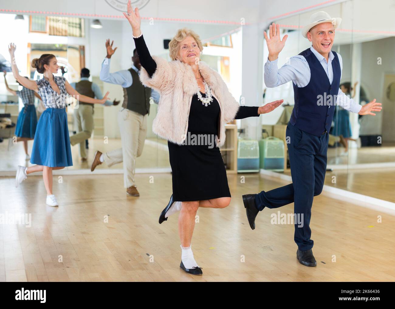 Man and elderly woman performing jazz dance in dancing room Stock Photo ...