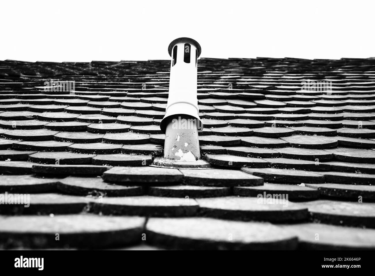 View on metal chimney on tiled roof in black and white Stock Photo - Alamy