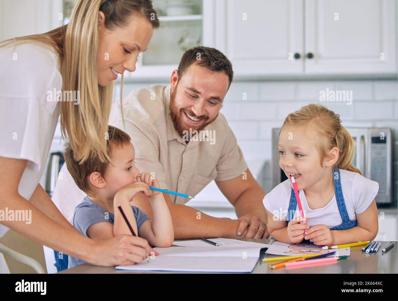 Caucasian parents helping children with homework. Happy siblings doing school work. Mother ...